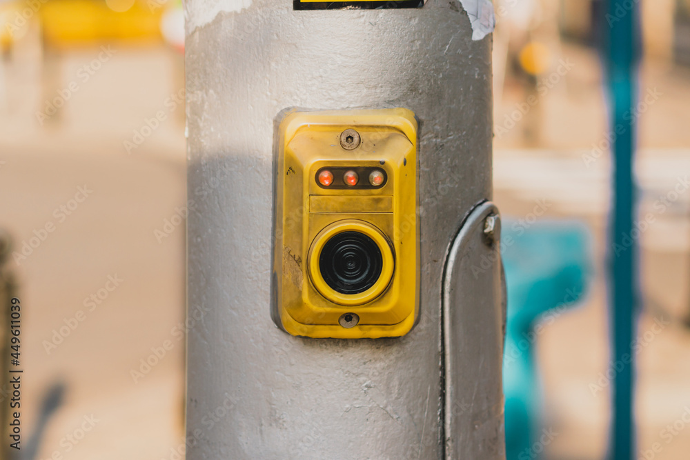 Yellow cross walk push button installed on a pole with red stop red ...