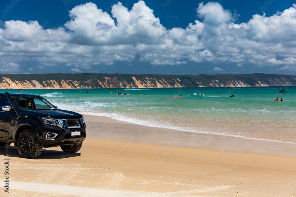 4WD vehicles and surfers at Double Island Point on a sunny day Stock ...