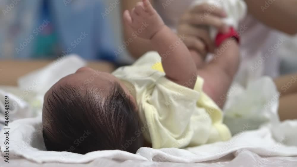 Select focus baby boy at bed. Mother clean the poop and wrap the diaper ...