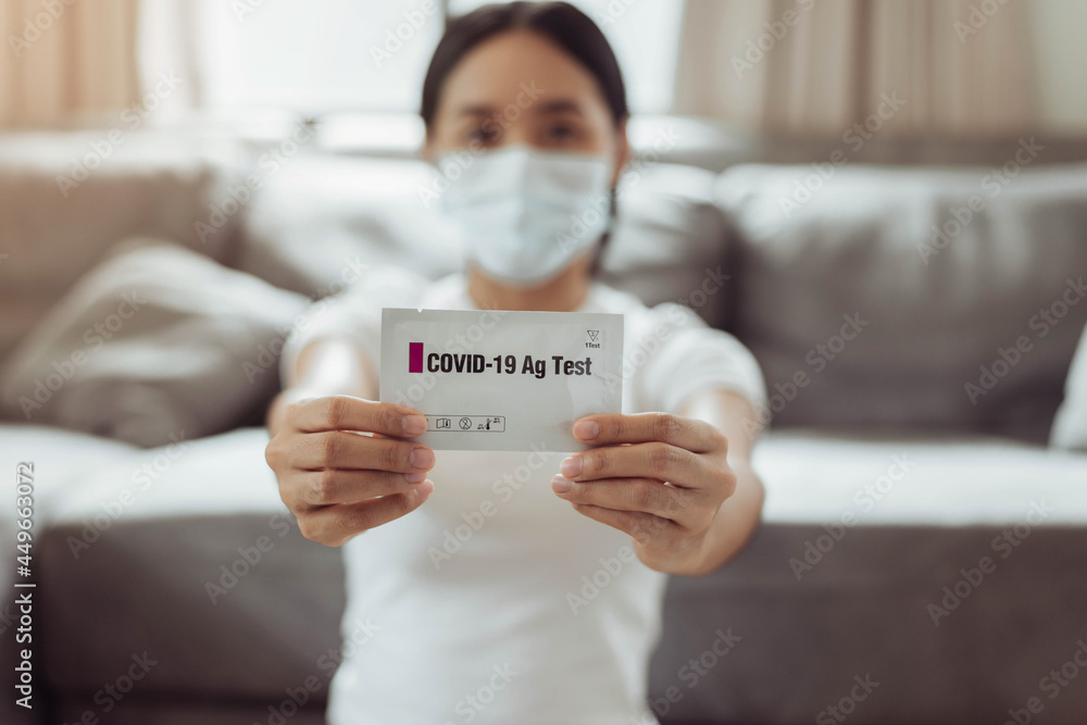 Young woman self test for COVID-19 at home with antigen kit. asian ...