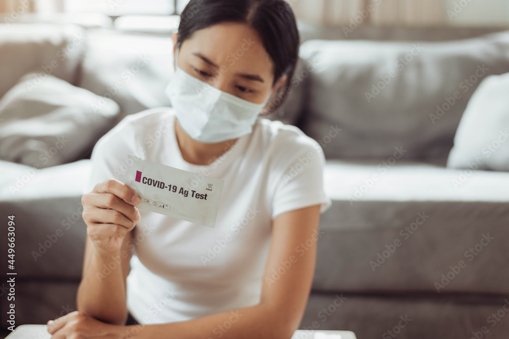 woman studying the instructions for a self test for COVID-19 with ...