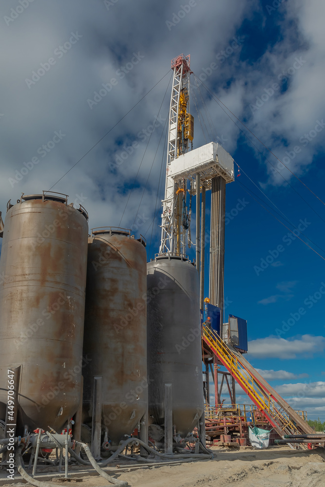 Drilling rig with well cementing equipment in the foreground ...