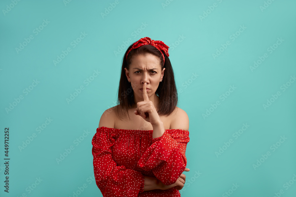 Frowning caucasian female, brunette in red dress with bare shoulders ...