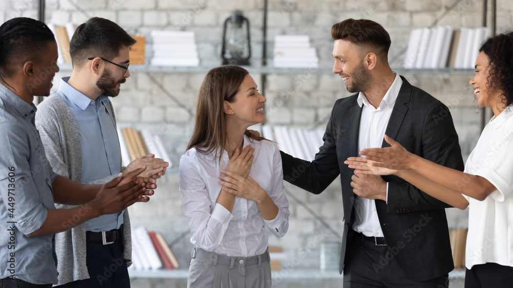 Smiling supportive diverse businesspeople congratulate excited young ...