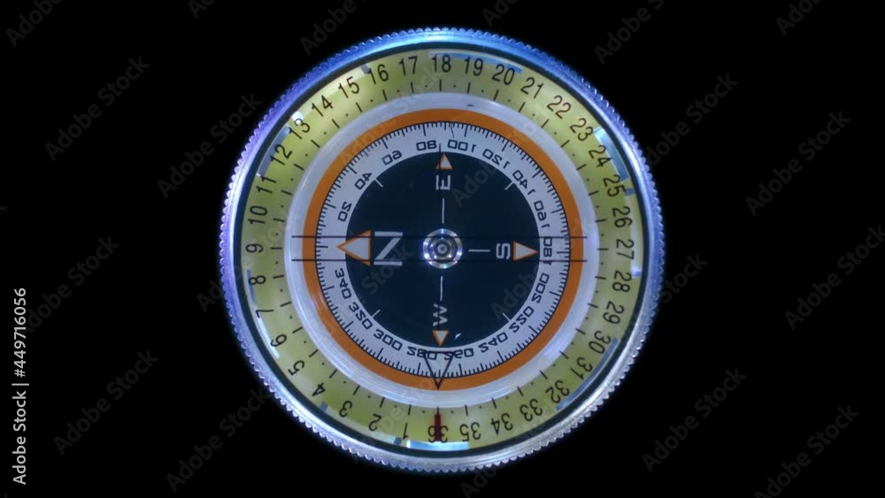 Compass with a rotating arrow on a black background, as a device for ...