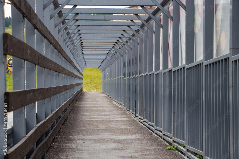 A long pedestrian tunnel with metal arches and mesh design. Aerial ...