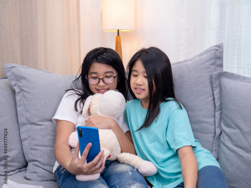 Happy siblings children sitting on sofa in living room speak with ...