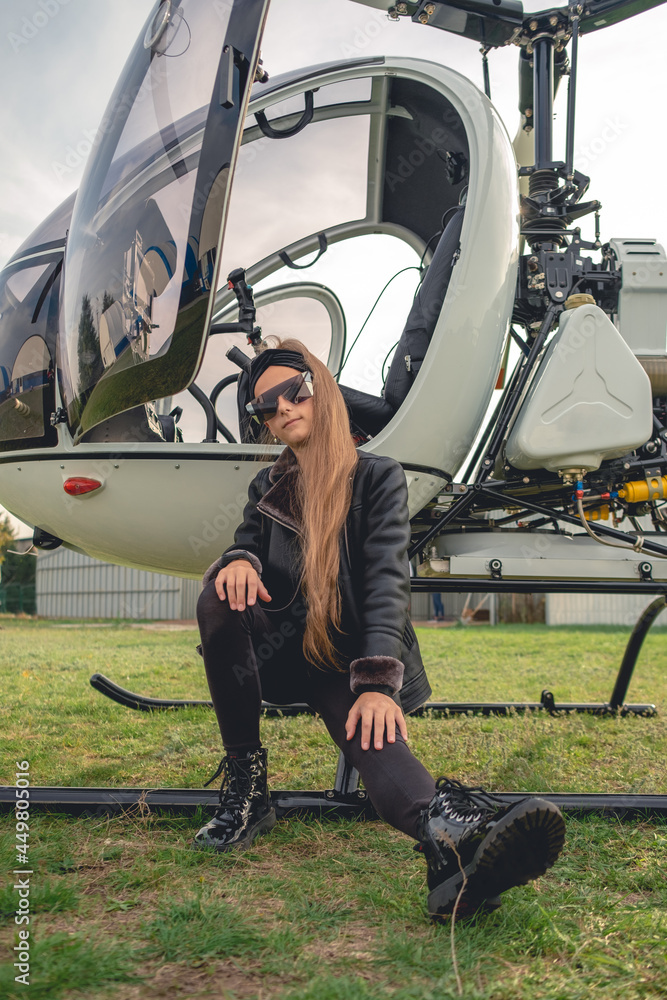 Tween girl sitting on footboard of open helicopter Stock Photo | Adobe ...