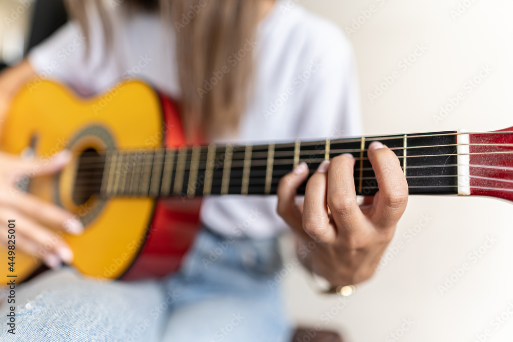 Detailed picture of a female's hand practising different chords on a ...