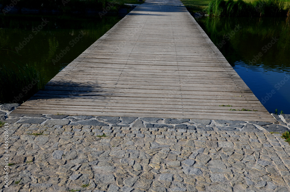 wooden wide pedestrian bridge over the river pond lake, without ...