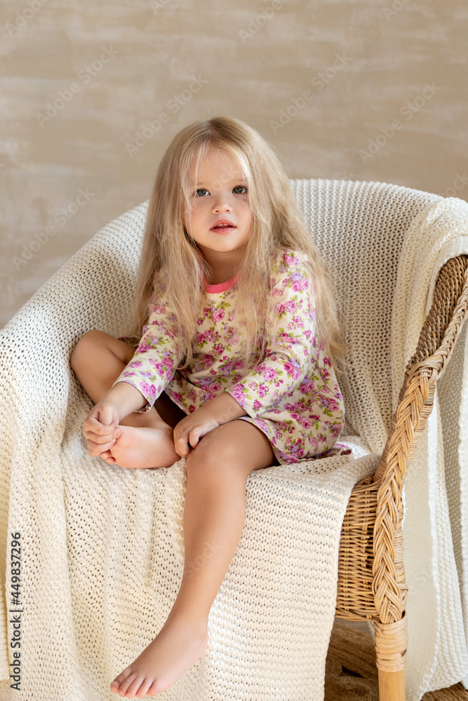 Little girl sits on a chair Stock Photo | Adobe Stock