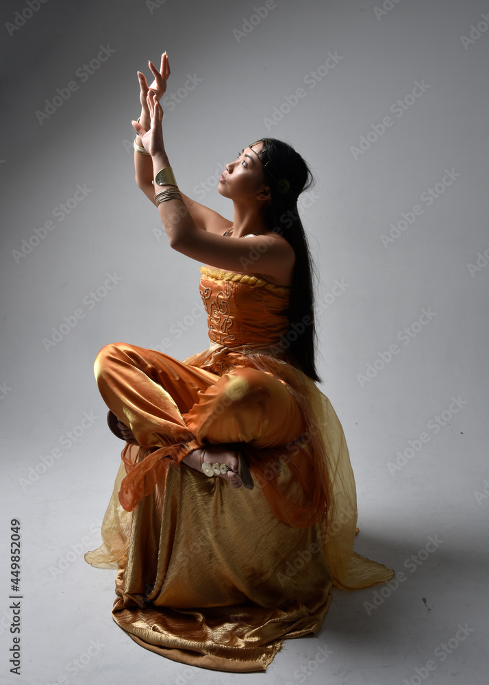 Full length portrait of pretty young asian woman wearing golden Arabian ...