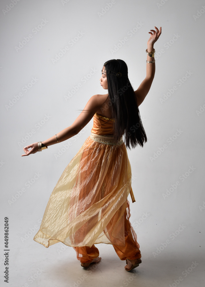 Full length portrait of pretty young asian woman wearing golden Arabian ...