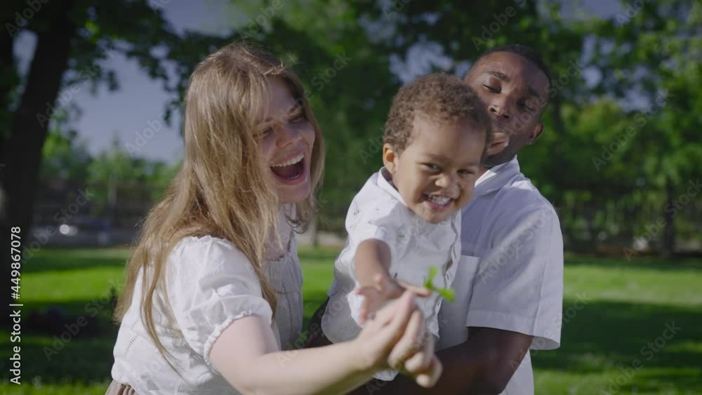 Young multiracial family in the park. Mother father and little boy are ...