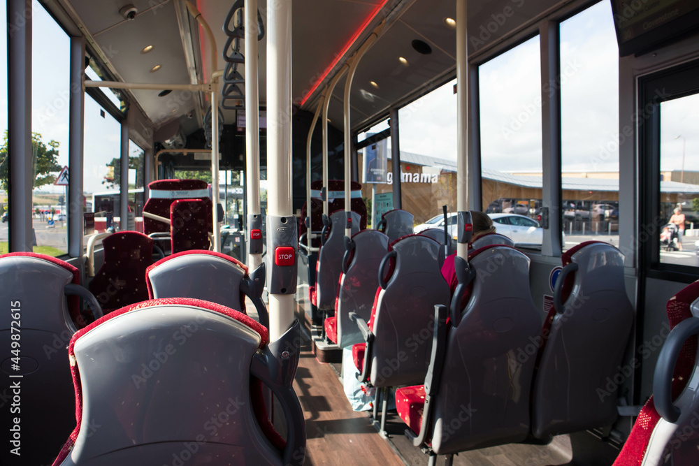 Interior of public transport bus showing seats and hand rail during a ...