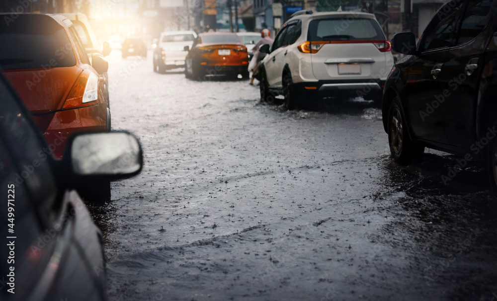 Morning traffic on rainy day with hard rain fall and flood in city ...