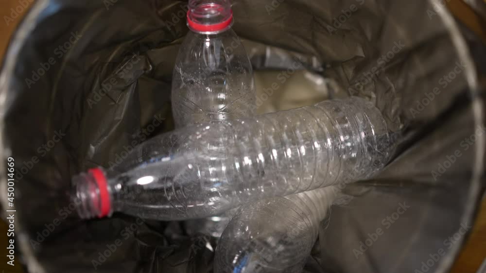 Close up shot, hand putting empty plastic drinking water bottle into ...
