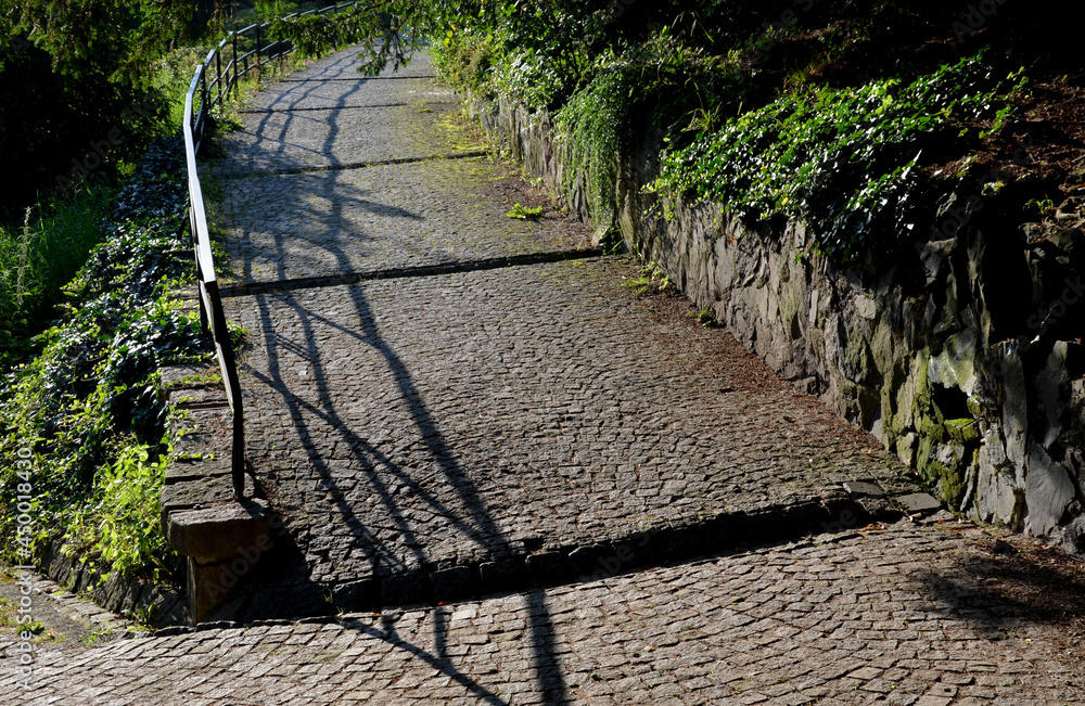 metal black railing copying the slope of a paved park path with ...
