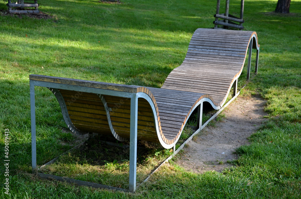 design bench in the shape of a wavy line. wooden paneling on a metal ...