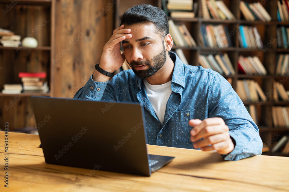 Frustrated Indian freelancer guy staring at the laptop screen with ...