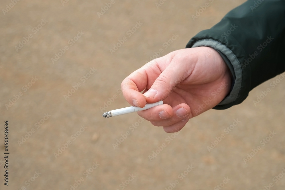 Tobacco smoke addiction, unhealthy lifestyle concept. Man's hand with a ...