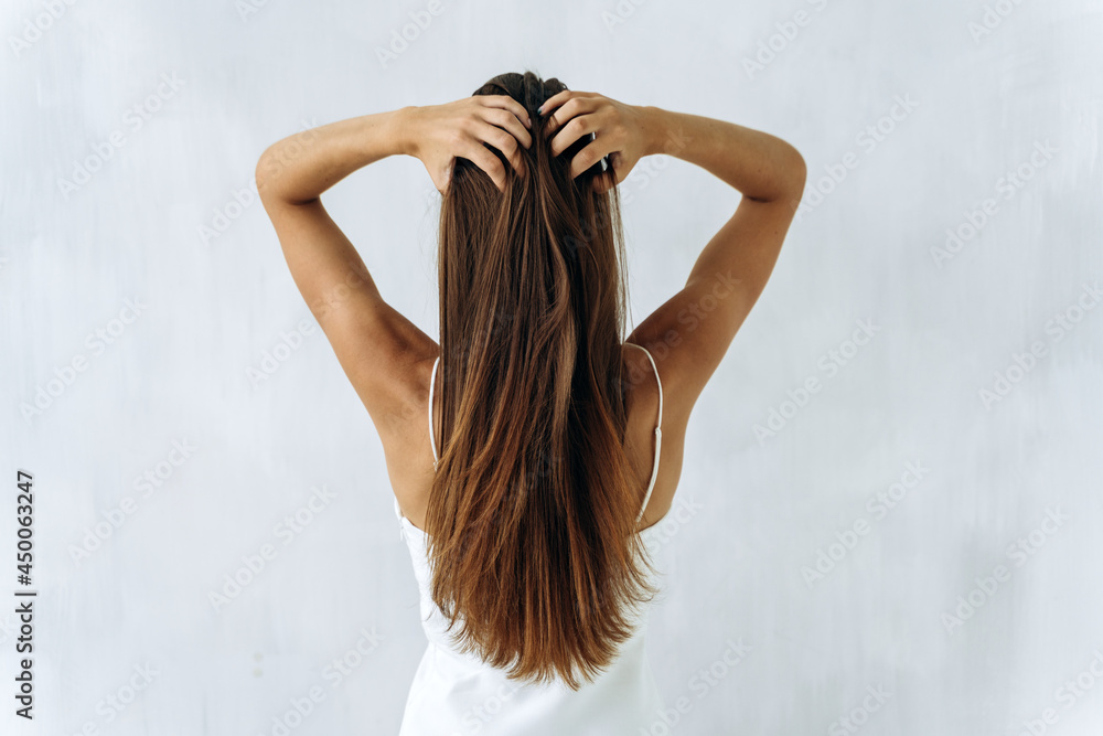 Beauty and care of hair. Waist up back side portrait of young brunette ...