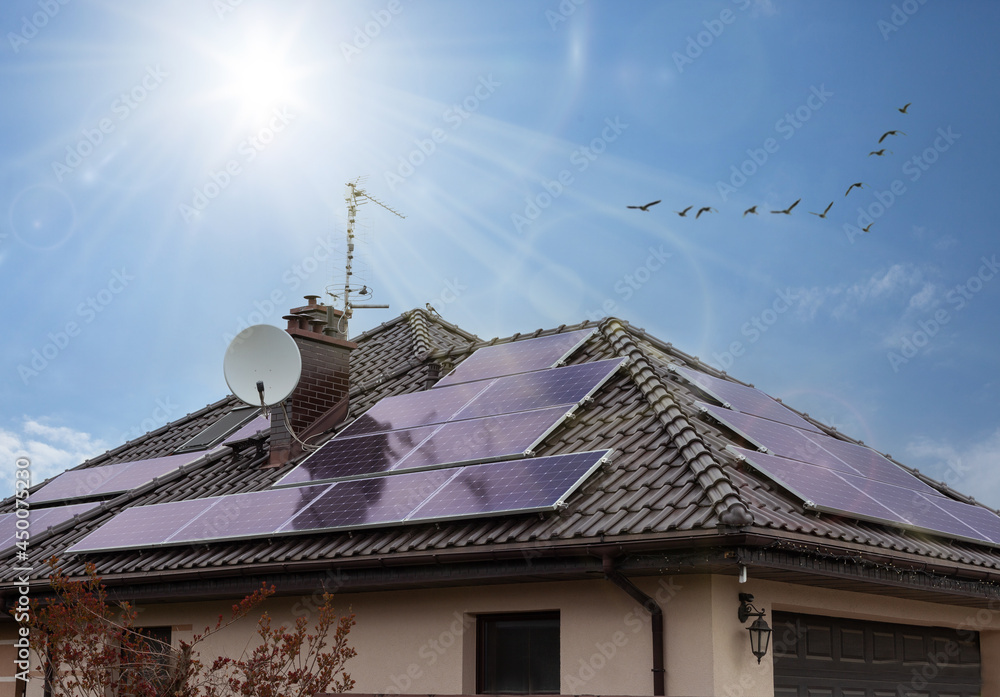 Solar panels on a roof. Beautiful, modern house and solar energy. Rays ...