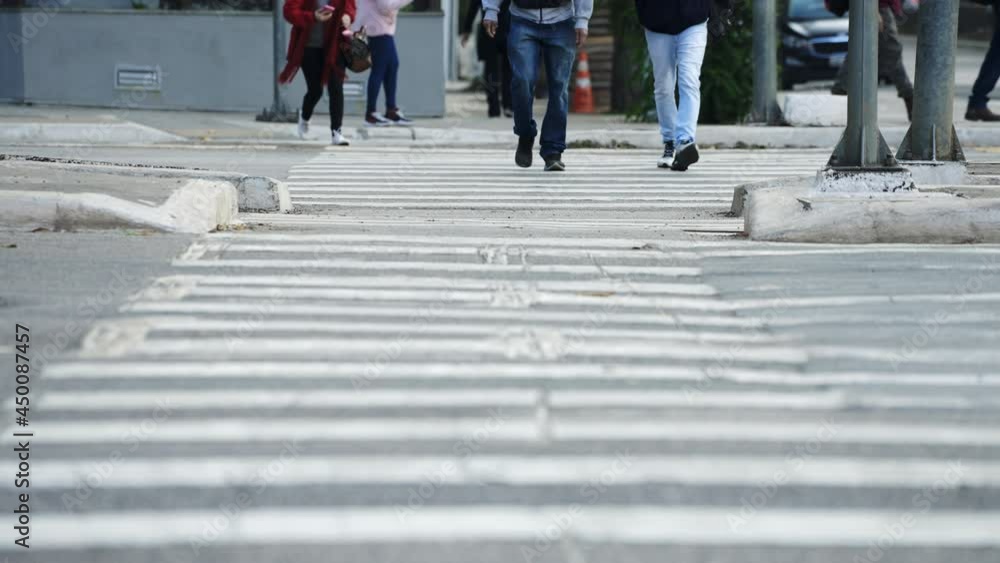 Pedestrians crossing a street's crosswalk of a big city in daylight ...