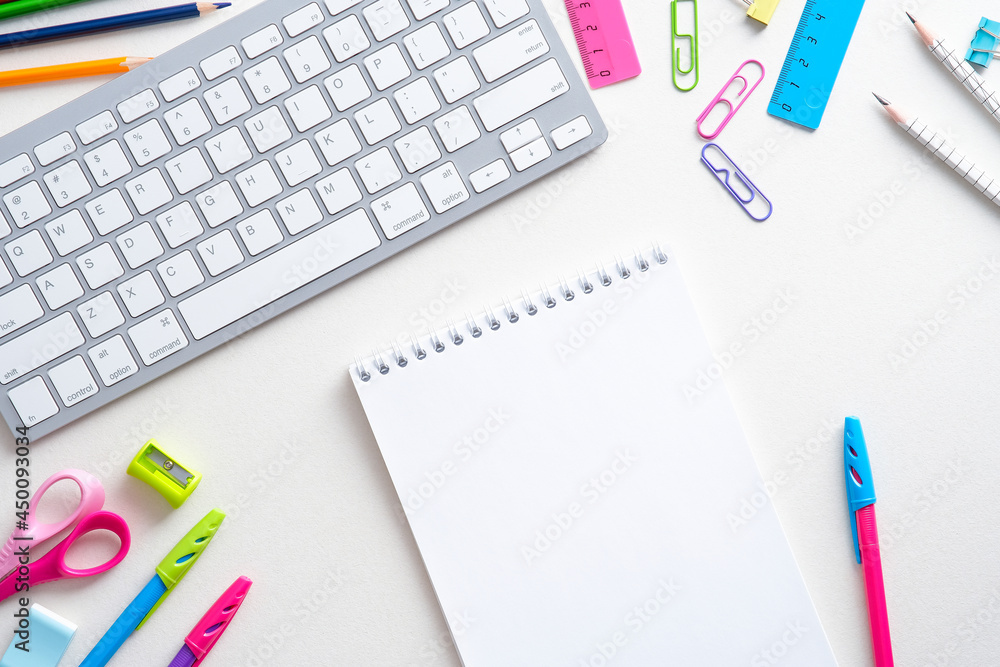 Flat lay paper notepad with colorful school supplies and keyboead on ...