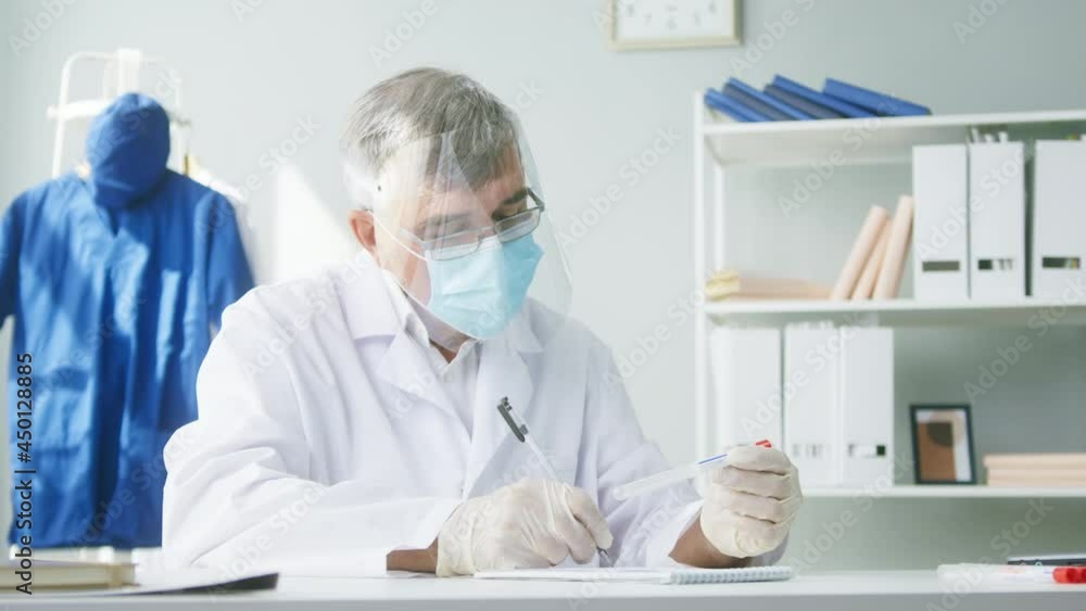 PCR test in laboratory, aged doctor in glasses holding COVID-19 swab ...