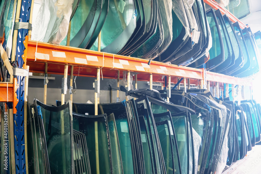 Lots of windshields for different cars on service station shelves ready ...