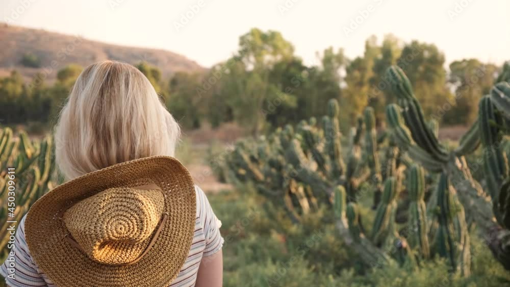 Video „Girl in straw hat waving goodbye in Cactus field. Blond woman ...