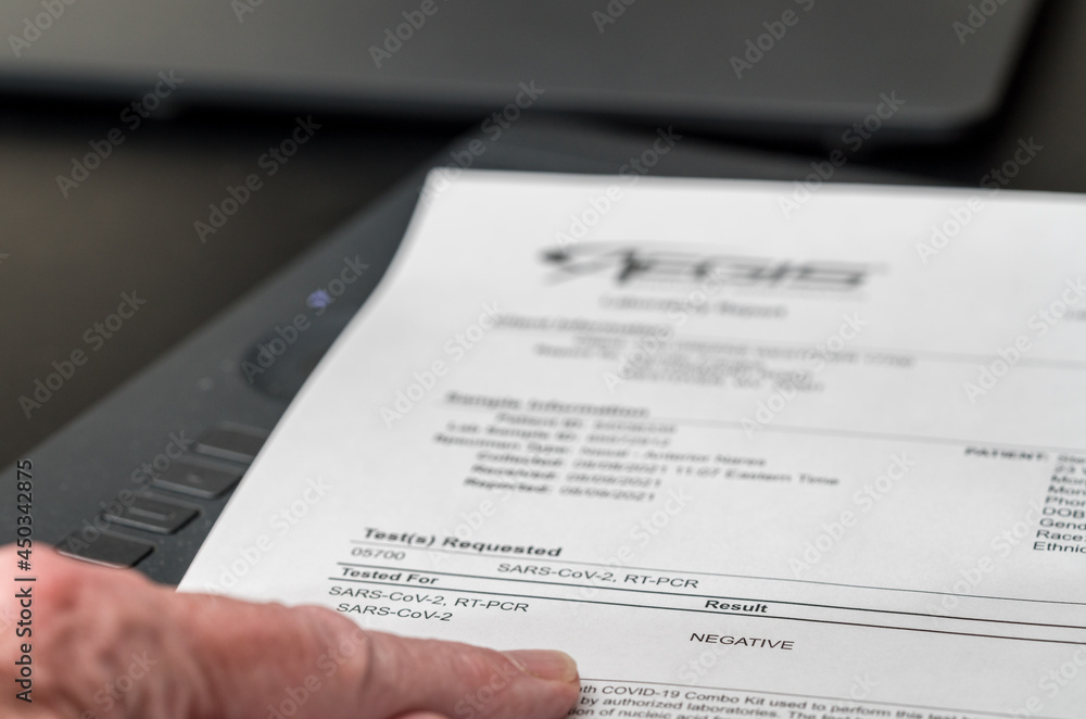 FInger pointing at paper printout showing a negative result for PCR ...
