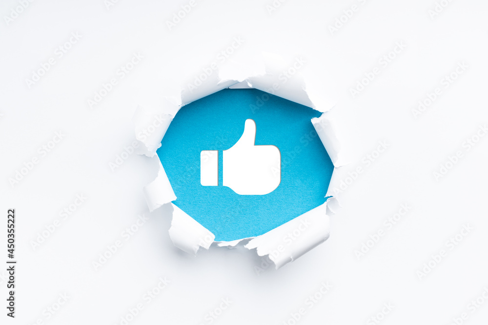 torn paper revealing a thumbs up symbol Stock Photo | Adobe Stock