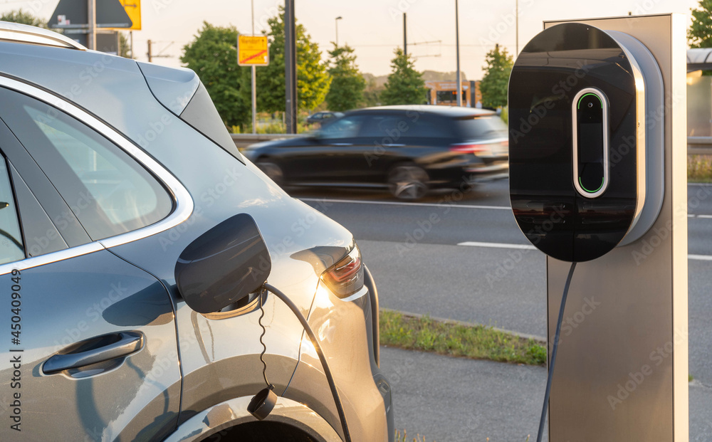 battery electric vehicle charging at a charging station, electric ...