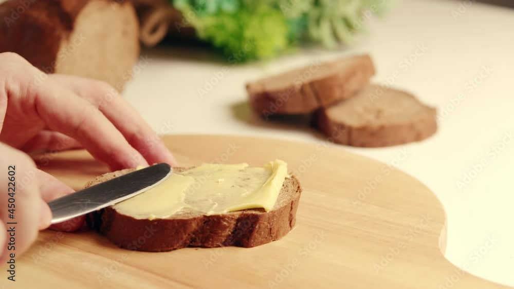 Smear organic butter on bread. Soft butter spreading on slice of ...