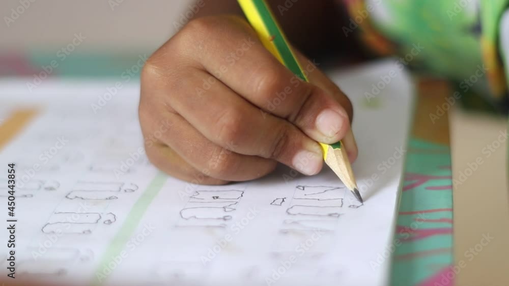 Kid doing lesson at home. Child boy writing in worksheet with pencil ...