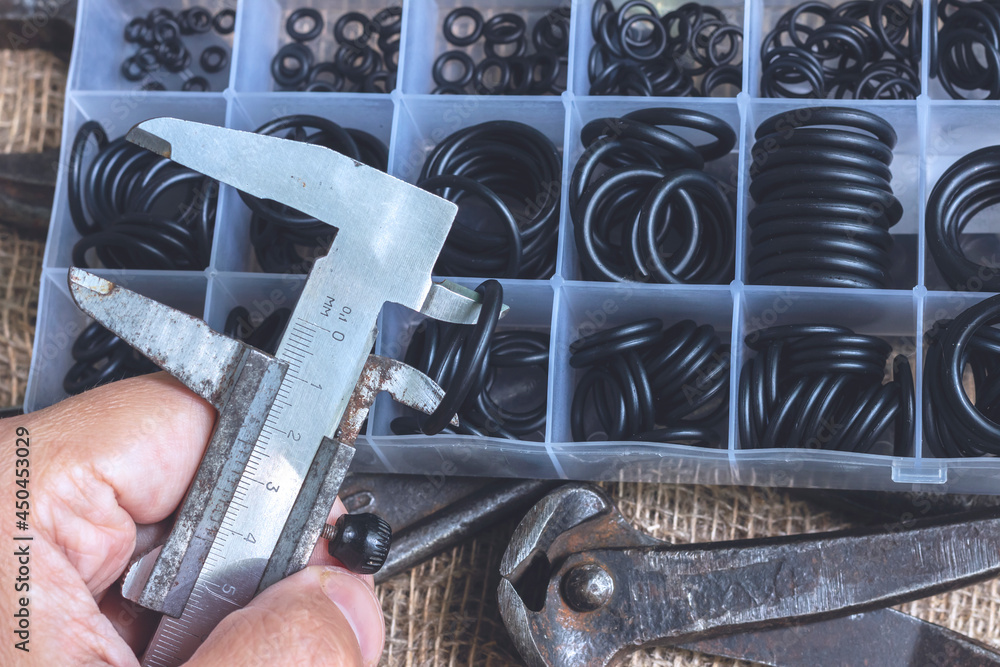 Measuring the diameter of the rubber ring with a caliper. A man is ...