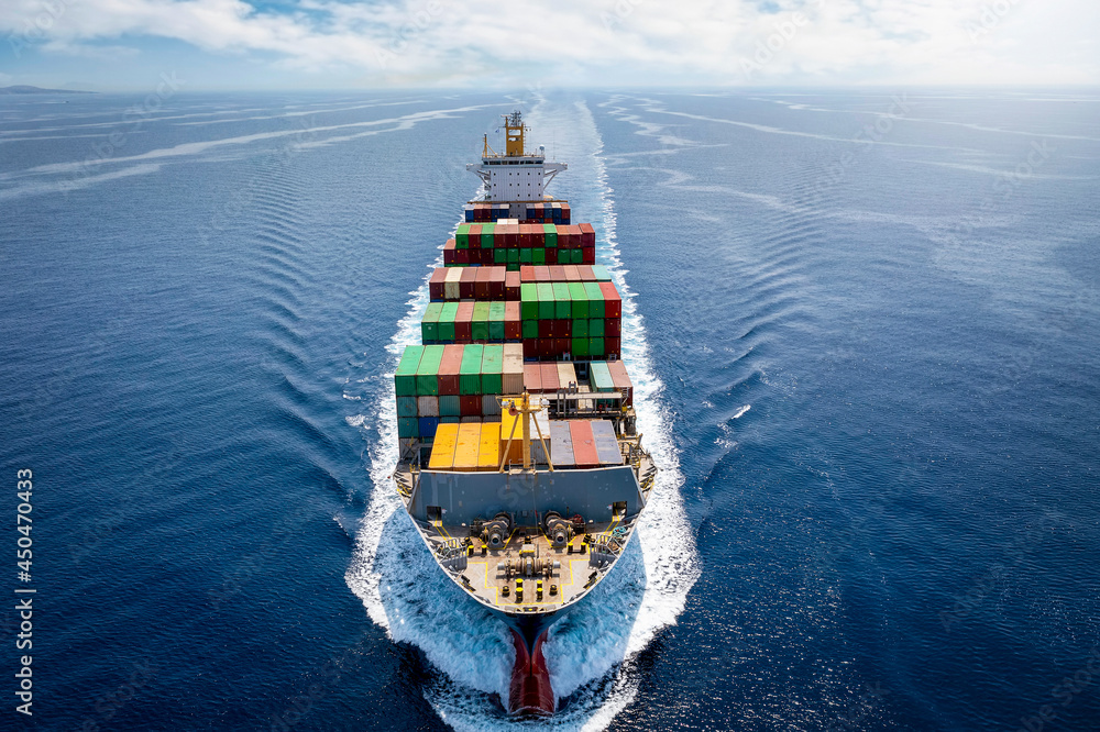 Aerial front view of a loaded container cargo ship in full motion on ...