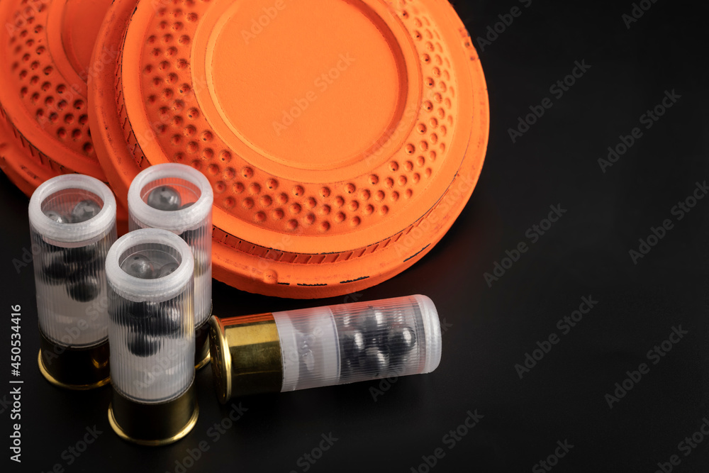 Clay shooting target and shotgun bullets on black background ,Clay ...