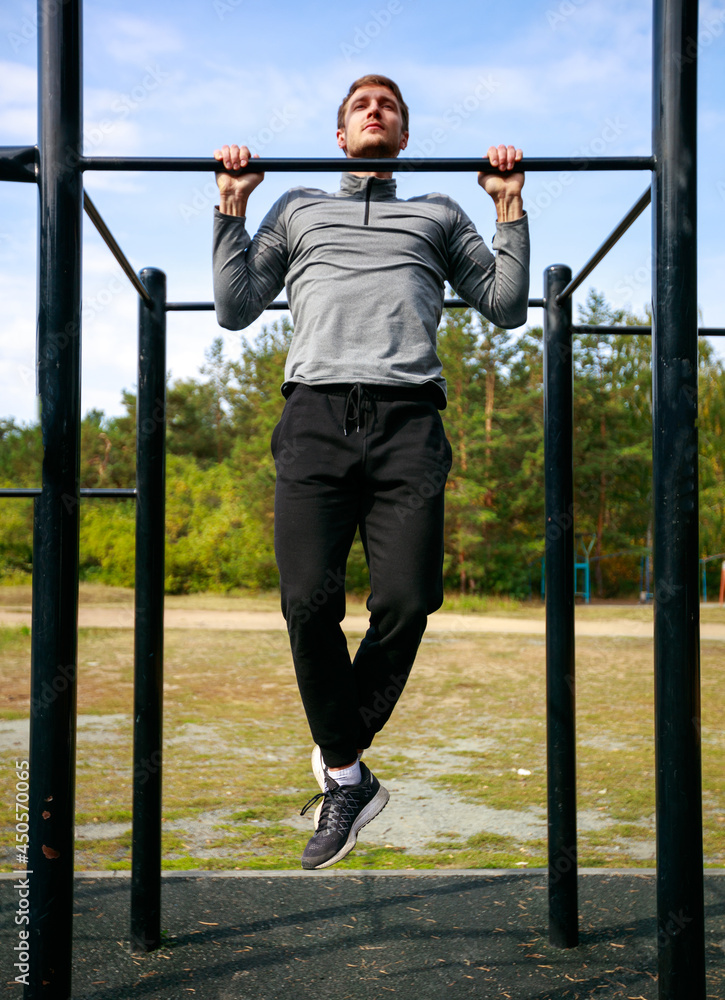 Muscular sports trainer on street workout exercising. Fit and athletic ...