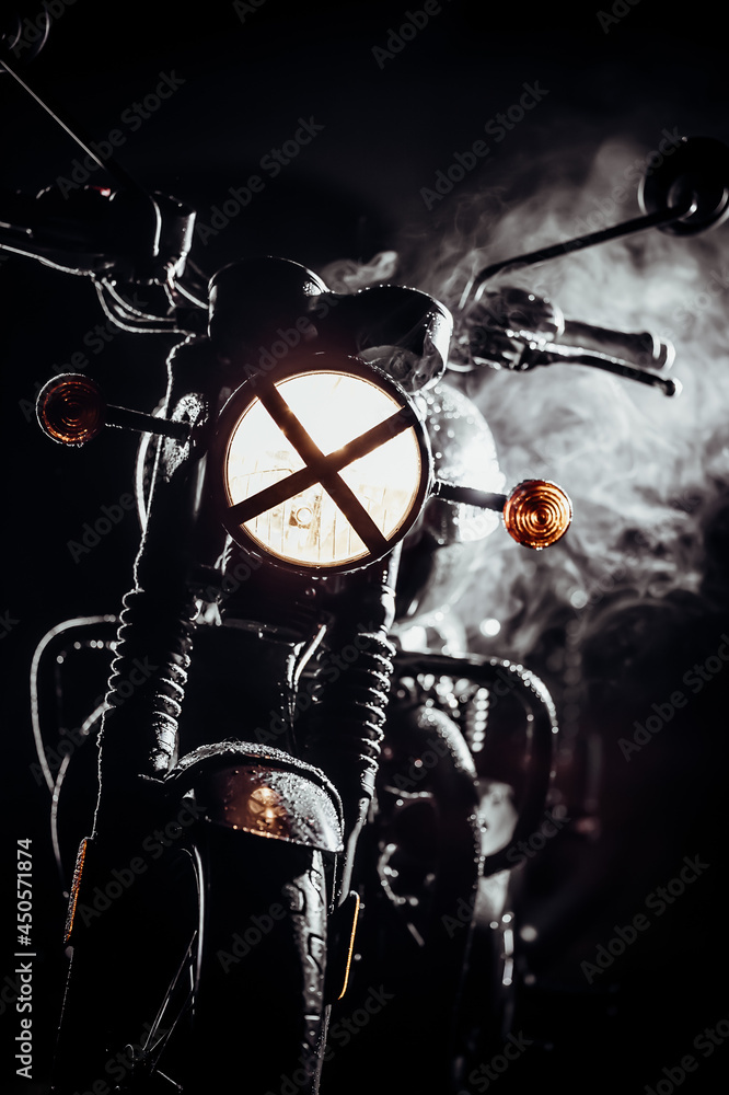 Silhouette of black retro styled motorcycle scrambler at night in fog ...
