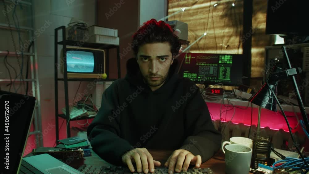 Tired hacker typing on keyboard at night, breaking password, using laptop and bypassing ...