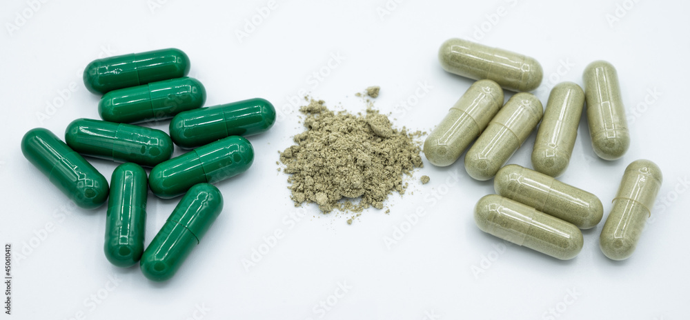 Andrographis paniculata capsules and powder on white background ...