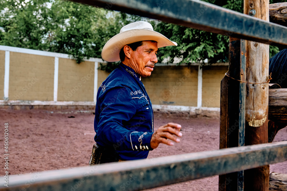 Mexican, hispanic, latino middle aged rancher in a blue shirt wearing a ...