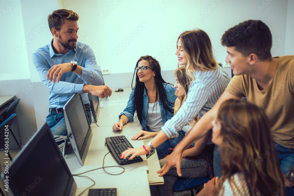 College students sitting in a classroom, using computers during class ...