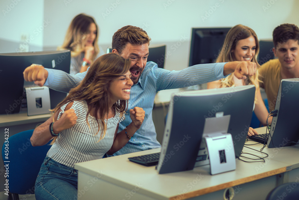 College students sitting in a classroom, using computers during class ...