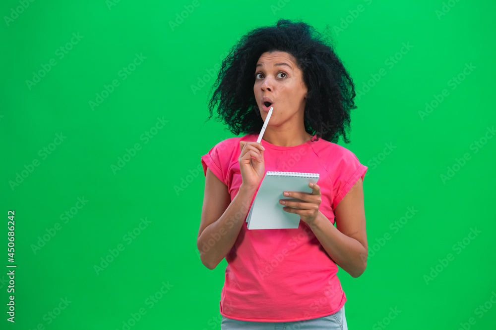 Portrait of young female African American thinking, then happy writing ...