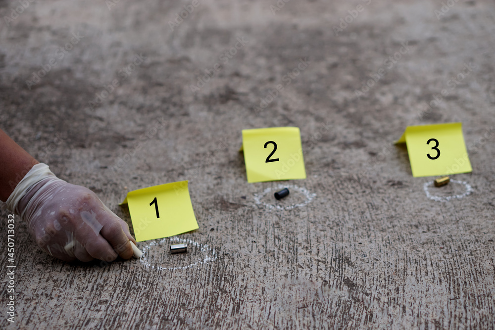Foto de Concept : Crime scene. Hand is drawing circle around bullet ...