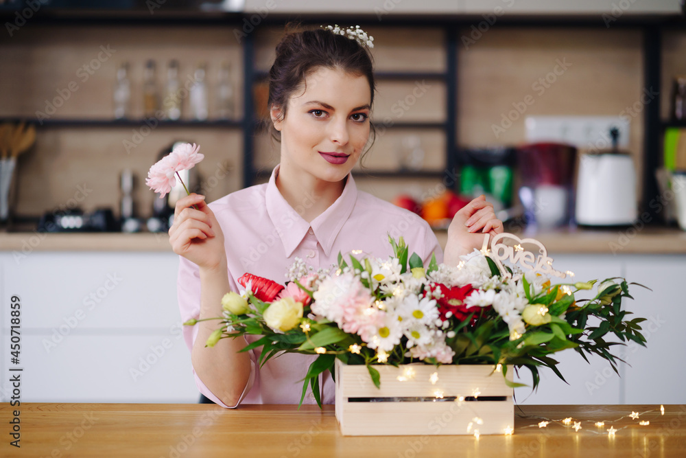 Florist at work: pretty young brunette woman making fashion modern ...